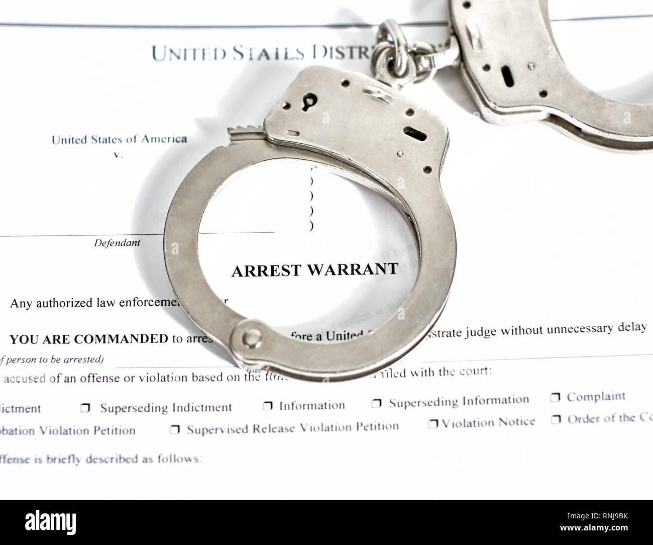 District Court Arrest Warrant court papers with handcuffs isolated on ...