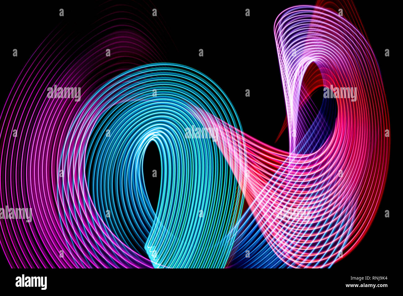 Abstract rainbow neon glowing crossing lines pattern. Dark background of colorful neon glowing ...