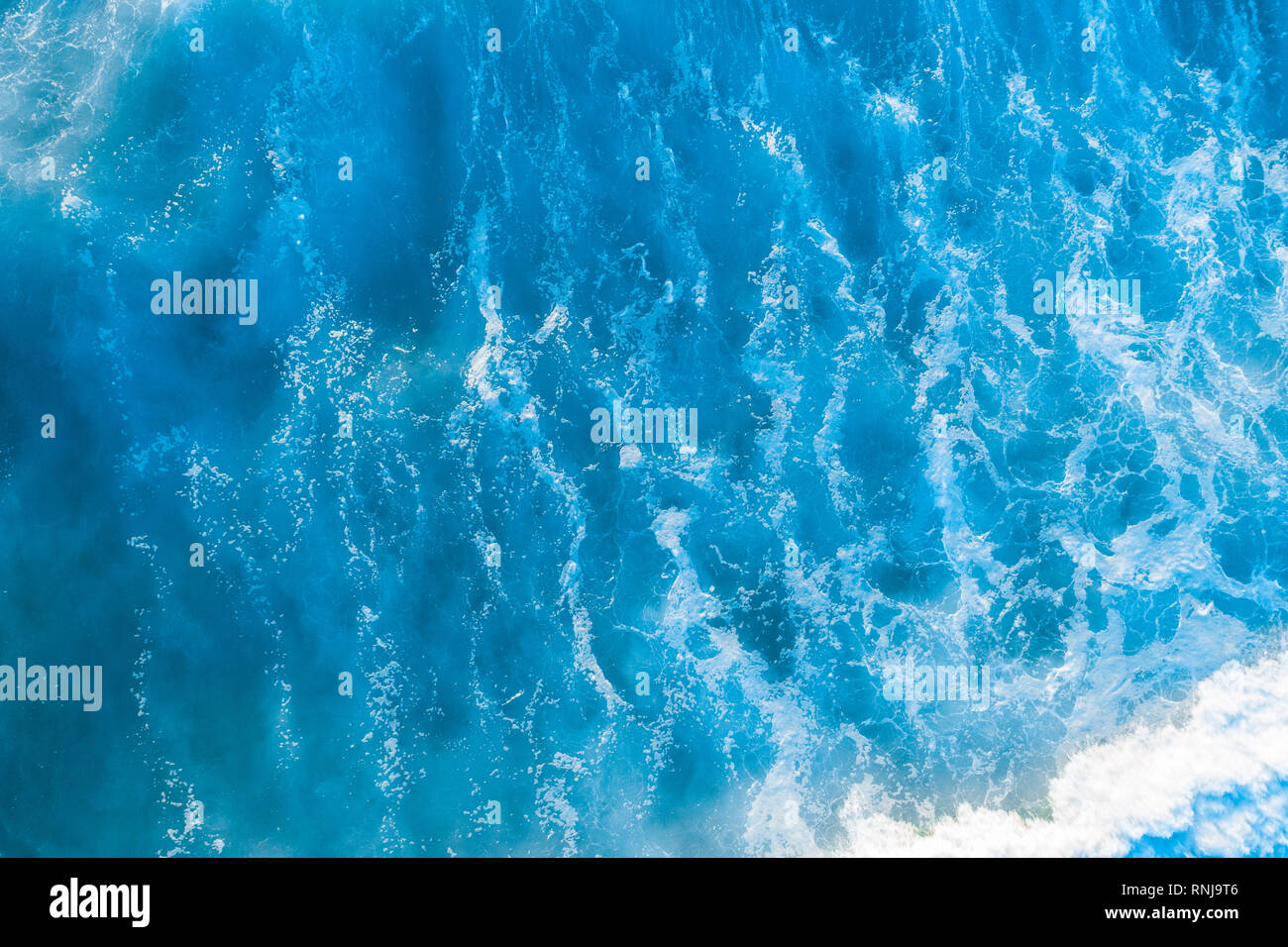 Looking down at beautiful blue ocean water and wave. Aerial view with ...