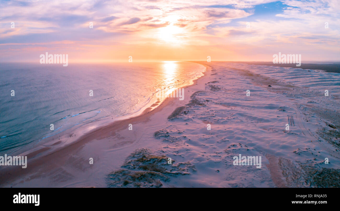 Aerial panorama of ocean coastline and white sand dunes at sunset. Anna ...