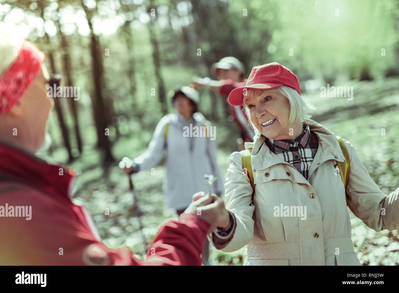 Smiling elderly woman walking in the forest with her partner Stock ...
