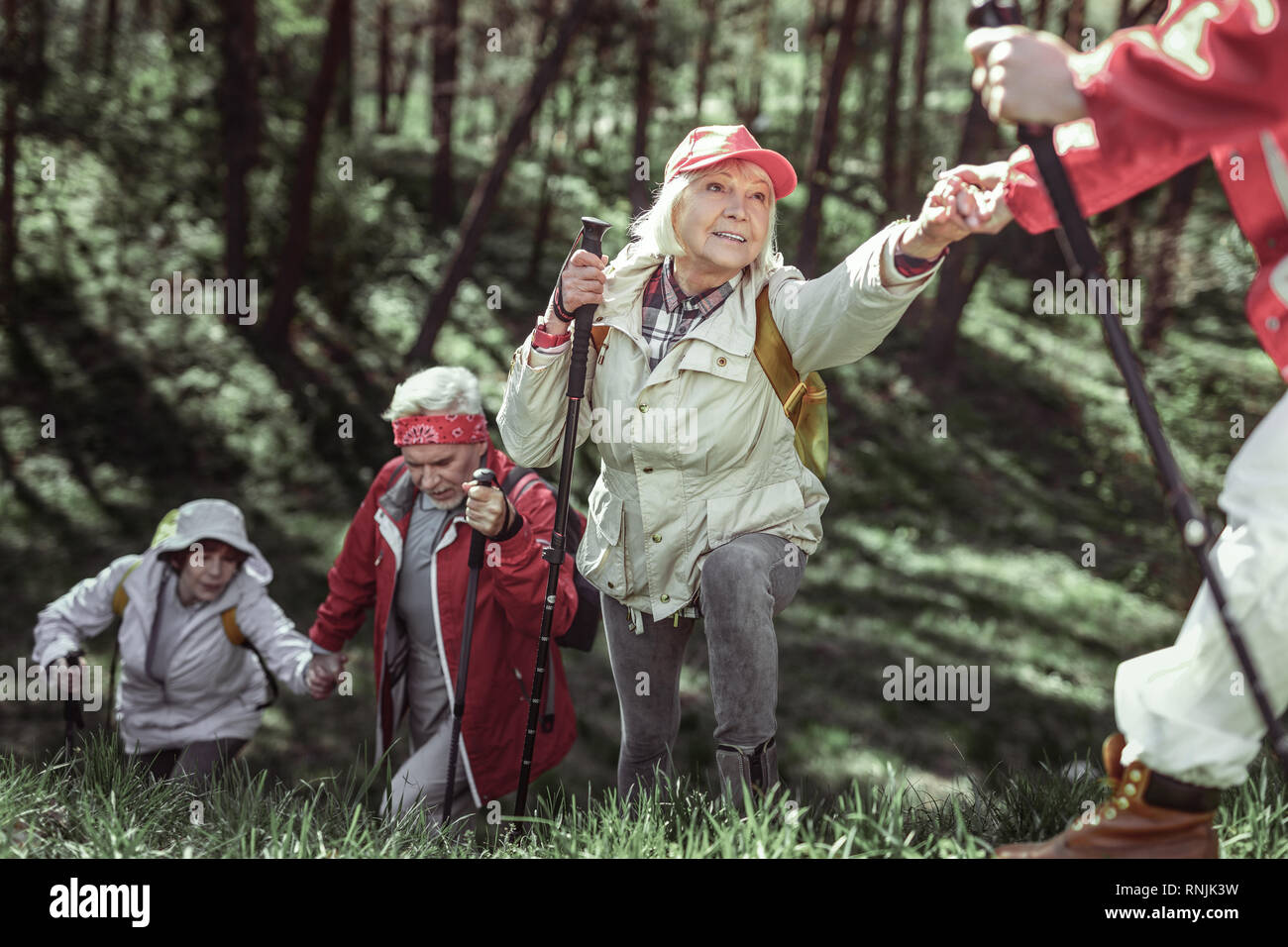 Guide with long hair helping old woman Stock Photo - Alamy