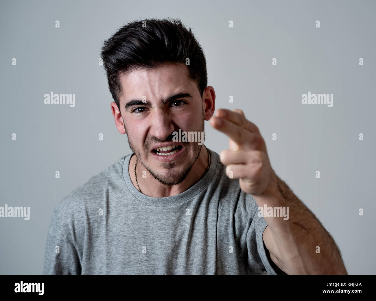 Close up portrait of young violent man with angry face looking furious ...