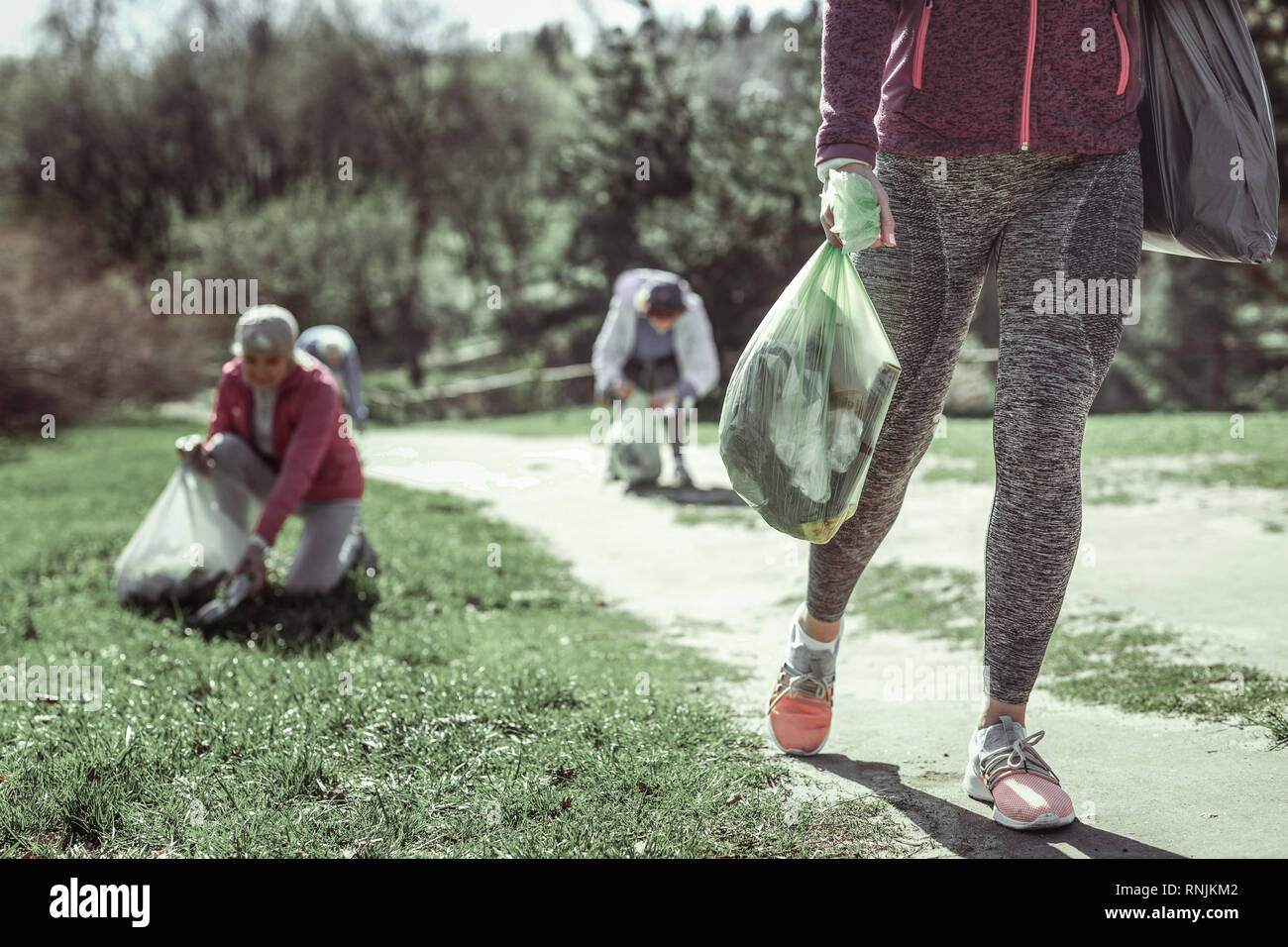 Woman in pink sport shoes going with trash Stock Photo - Alamy