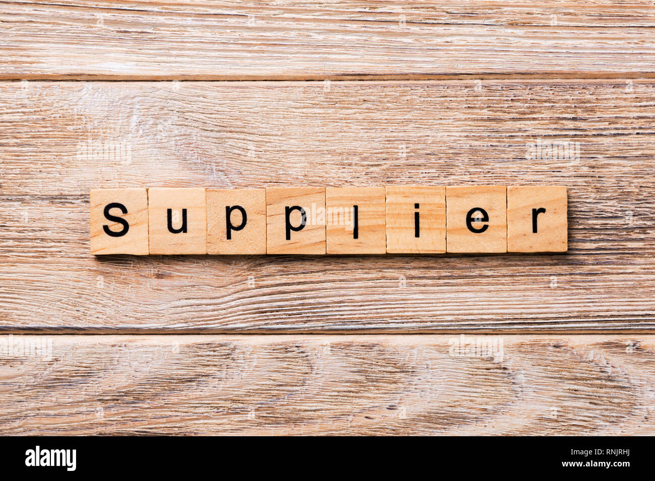SUPPLIER word written on wood block. SUPPLIER text on wooden table for ...