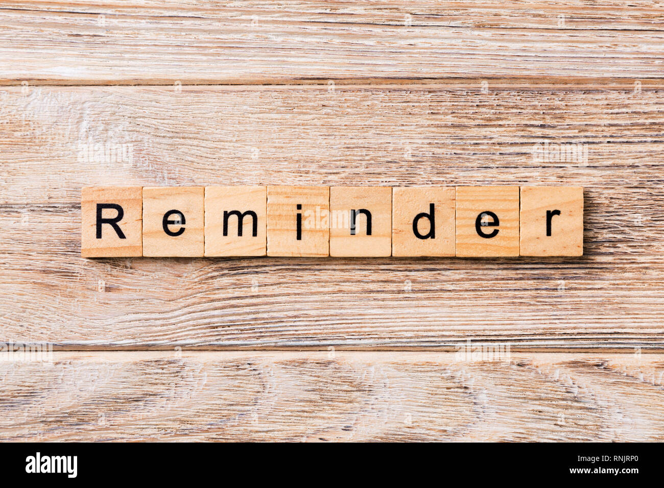 REMINDER word written on wood block. REMINDER text on wooden table for ...