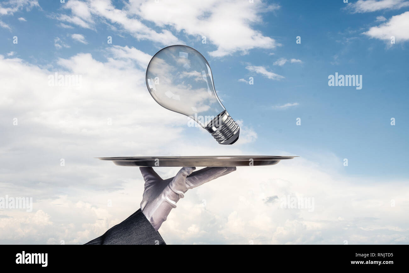 Hand of waitress presenting lightbulb on tray Stock Photo - Alamy