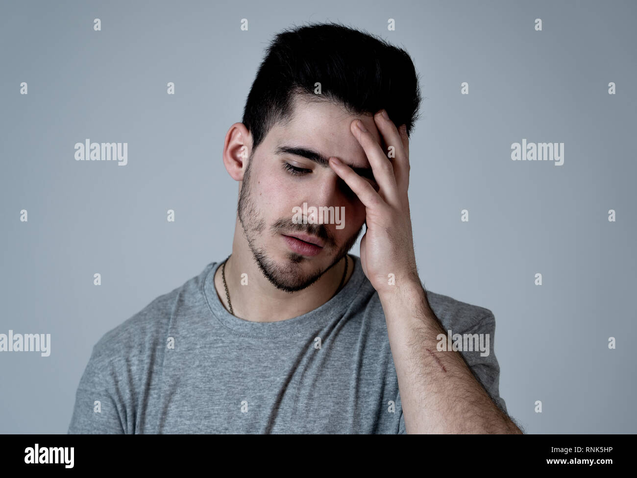 Close up portrait of handsome desperate young man suffering from ...