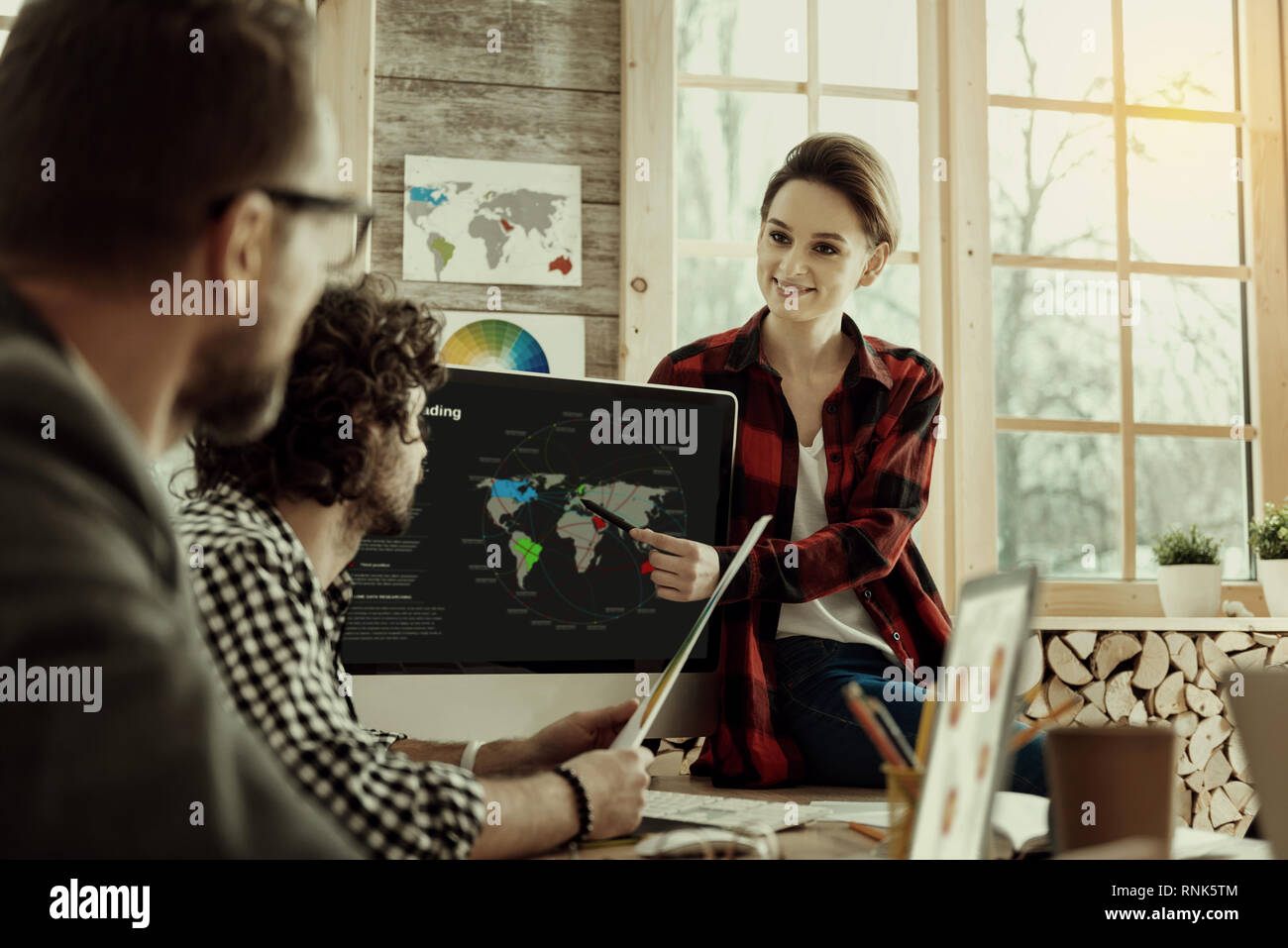 Good-looking professional presenting new idea to coworkers Stock Photo ...