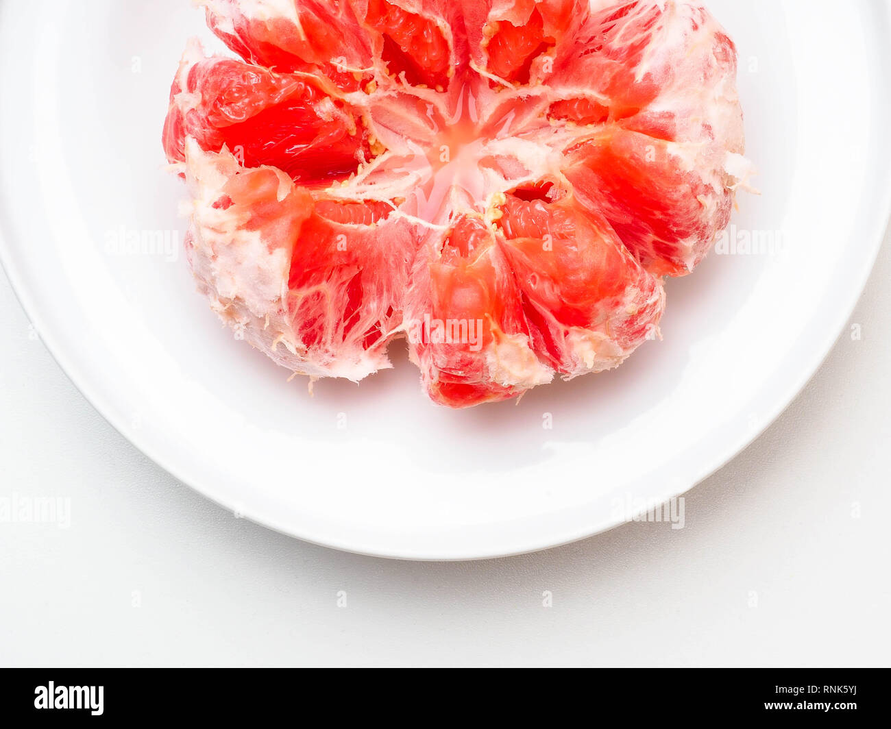 Grapefruit in plate isolated on white background. Round fresh fruit ...