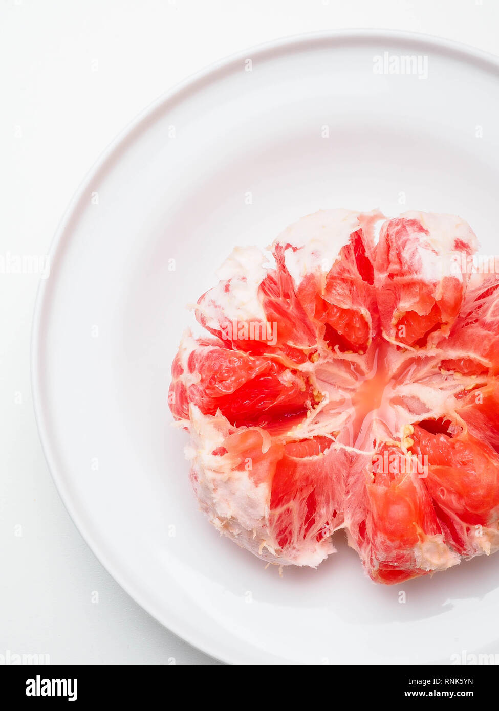 Grapefruit in plate isolated on white background. Round fresh fruit ...