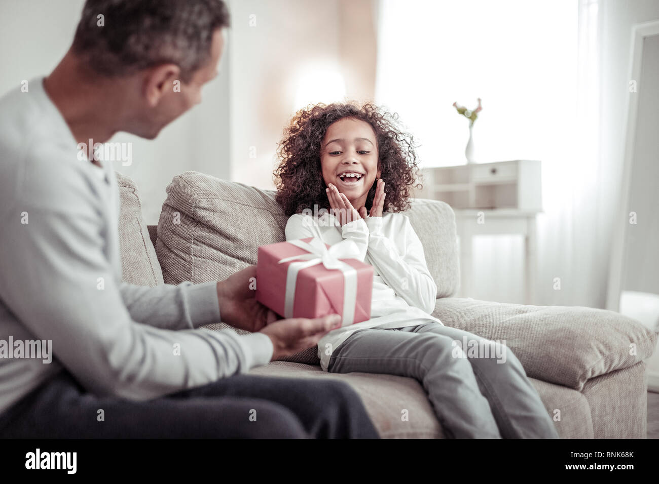 Happy little girl receiving a nice gift from her father Stock Photo - Alamy