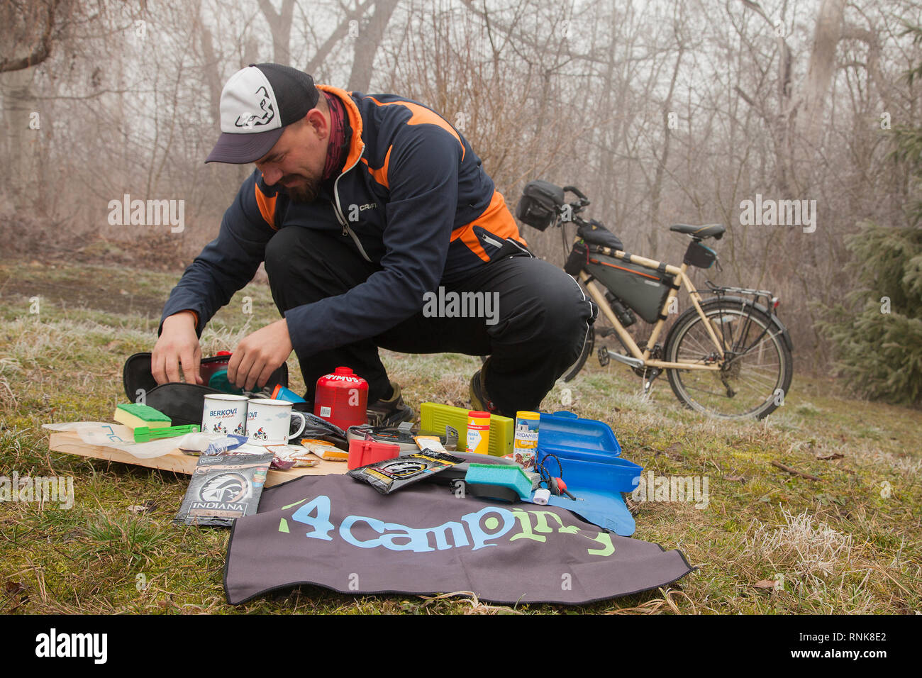 Person packing the bicycle panniers on a long cycle tour with family. A ...