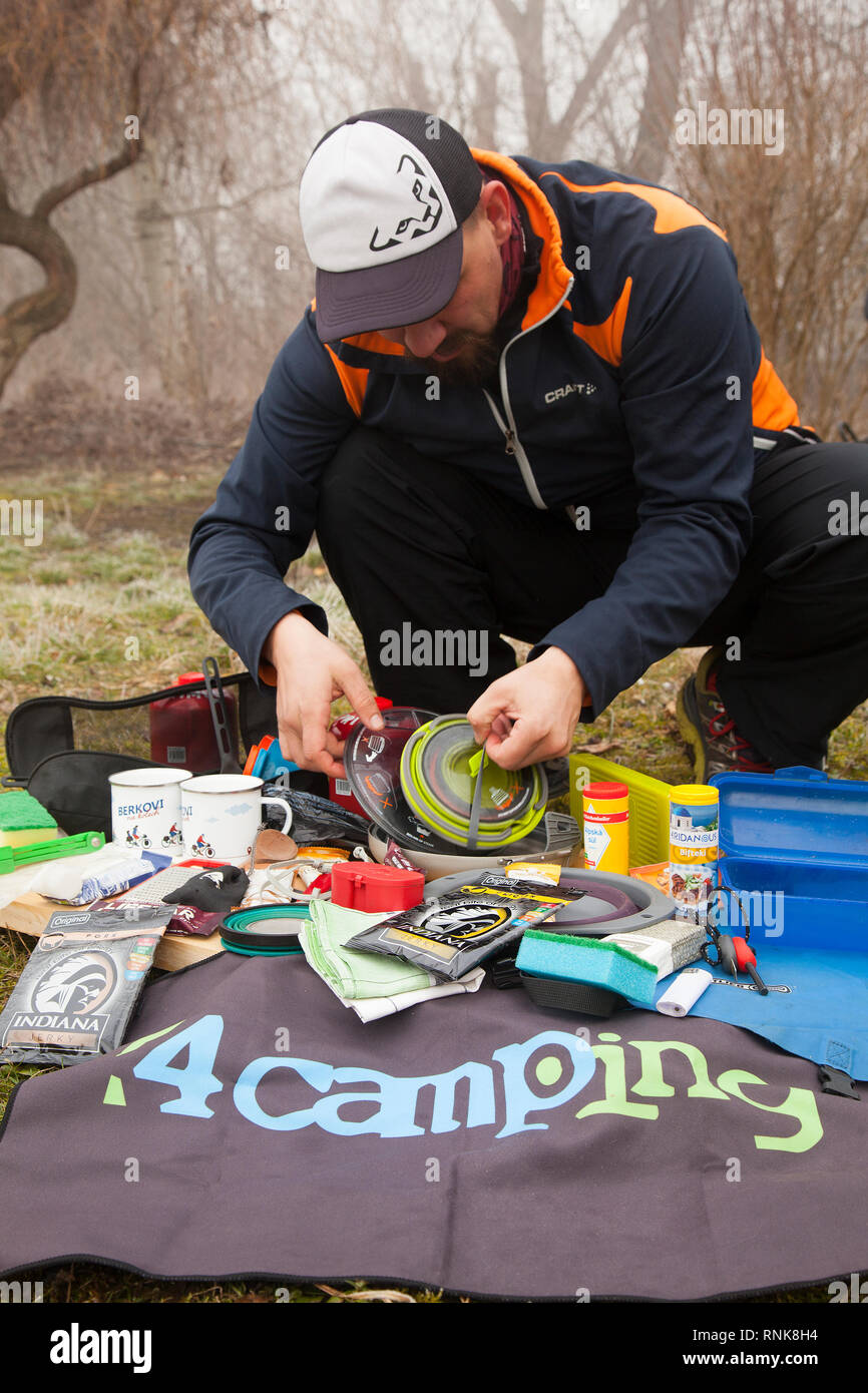 Person packing the bicycle panniers on a long cycle tour with family. A ...