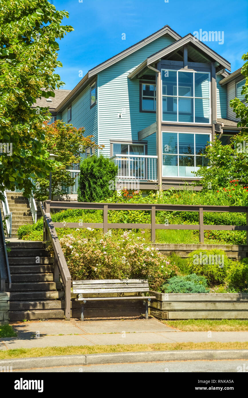 Facade of residential house built on land terrace with wooden bench in ...