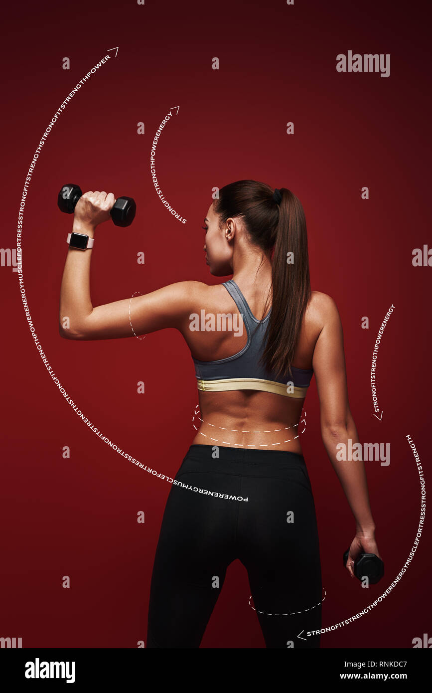 Photo of slim sporty woman doing exercises with small dumbbells over ...
