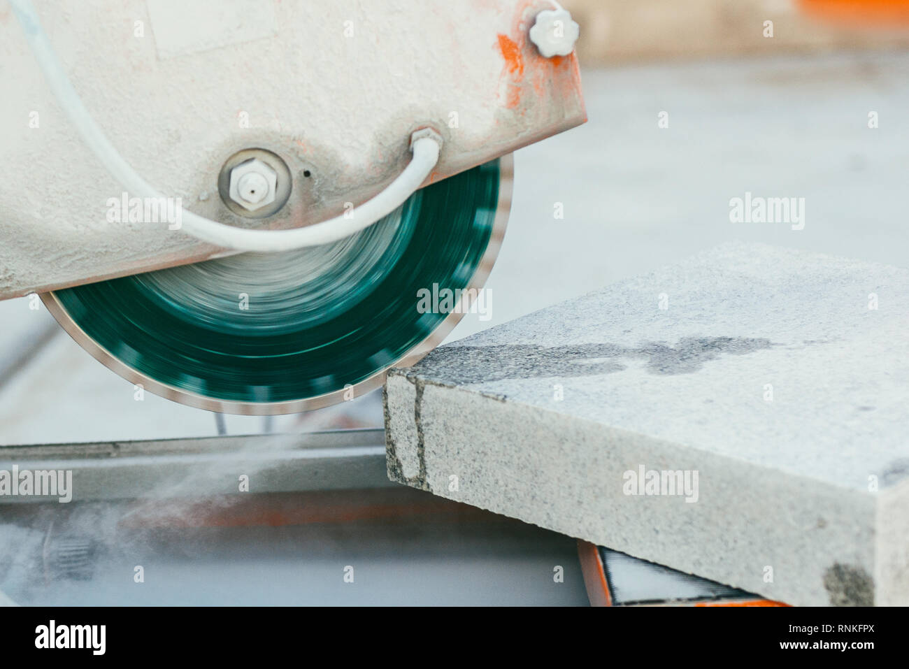 circular saw cuts a large piece of granite tiles for pavement Stock ...