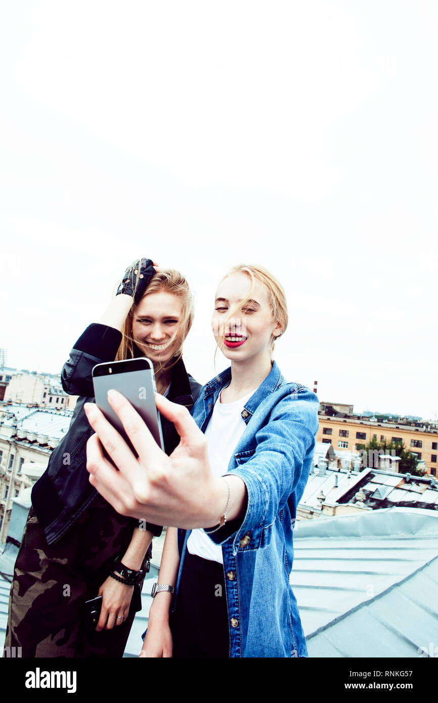 two cool blond real girls friends making selfie on roof top, lifestyle ...