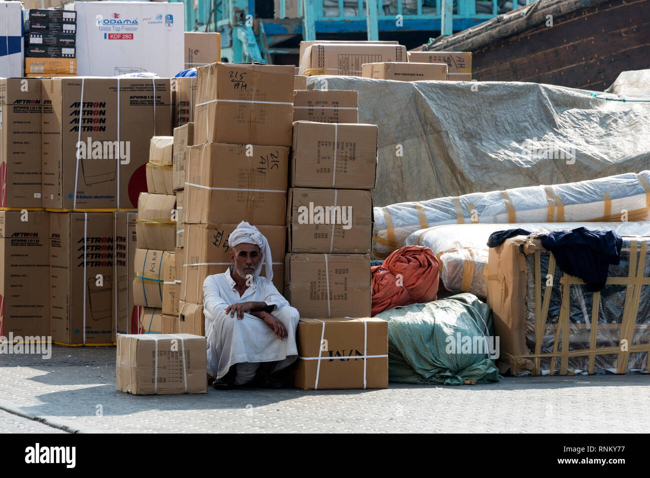 An Asian dock worker taking a break from loading goods onto a moored ...