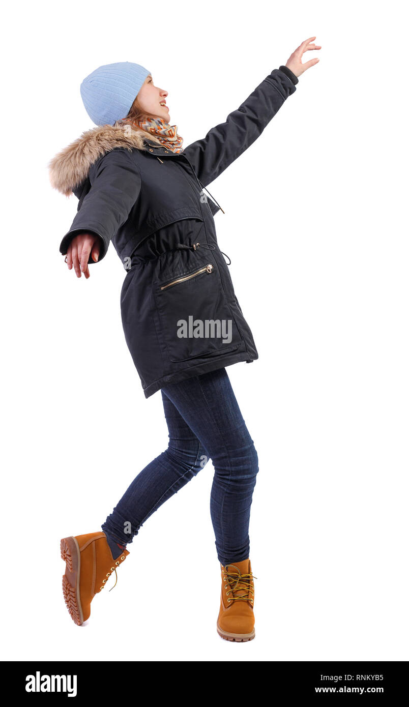 Side view of a woman in winter jacked dancing ballet. The girl is ...