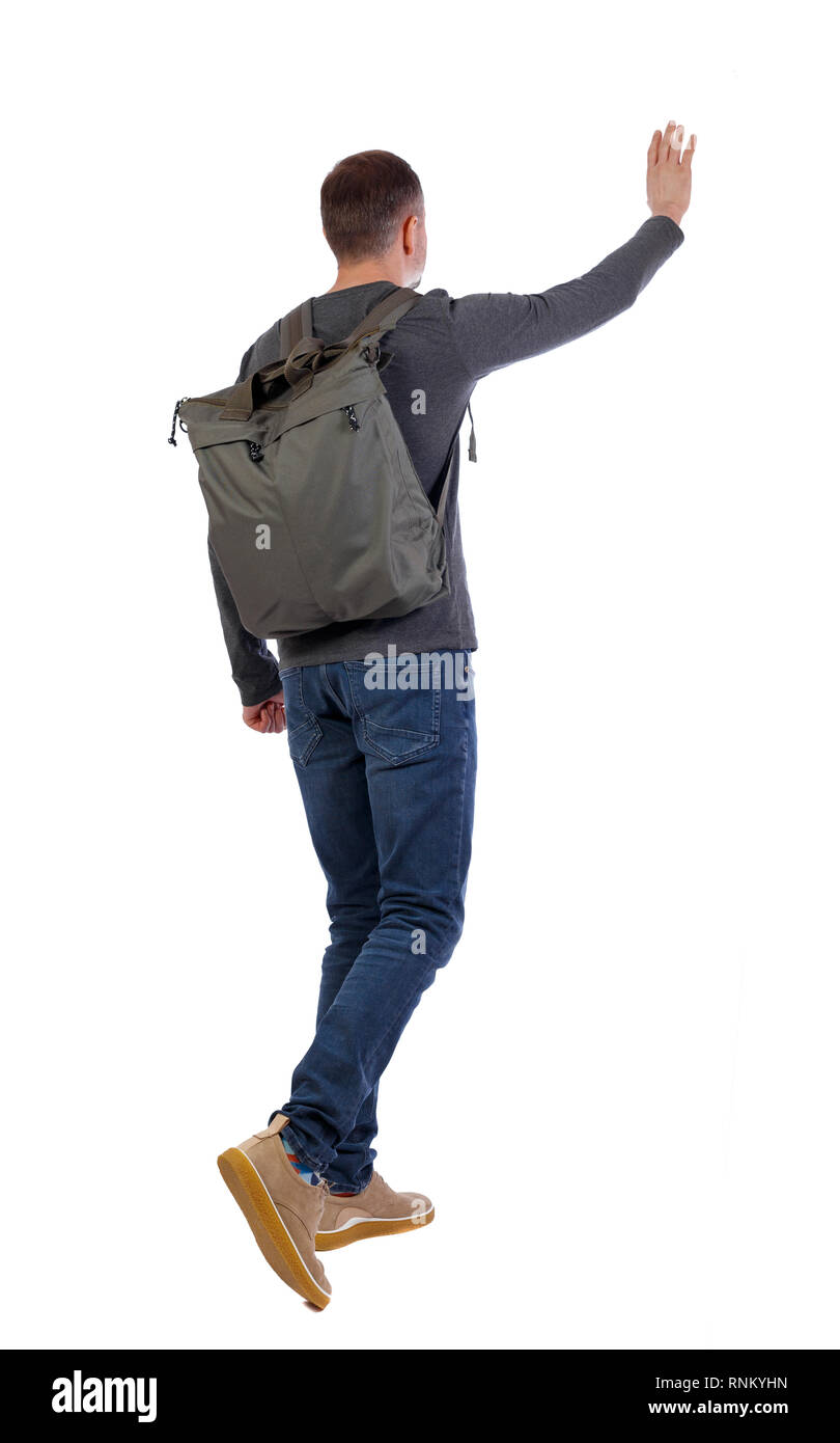 Back view of a walking man with a bag pointing his hand up. backside ...