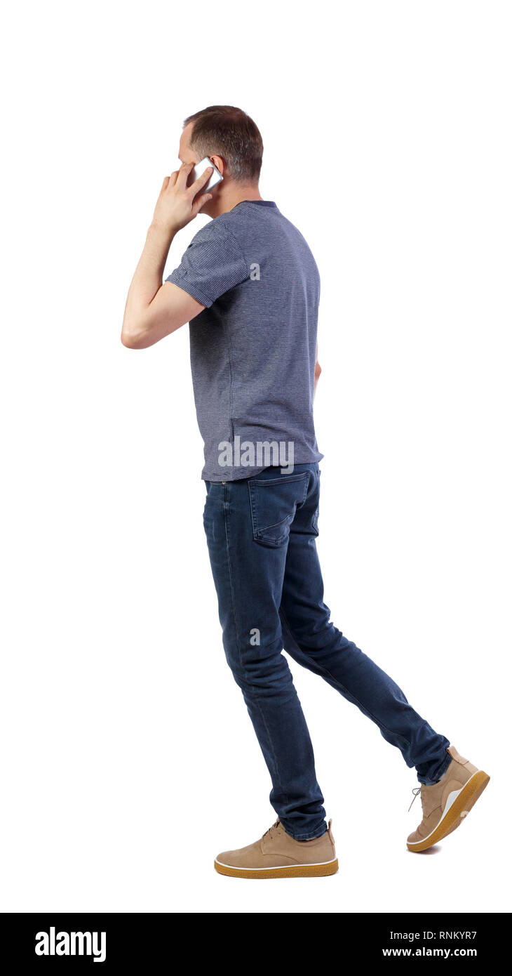 a side view of man walking with a mobile phone. backside view of person ...