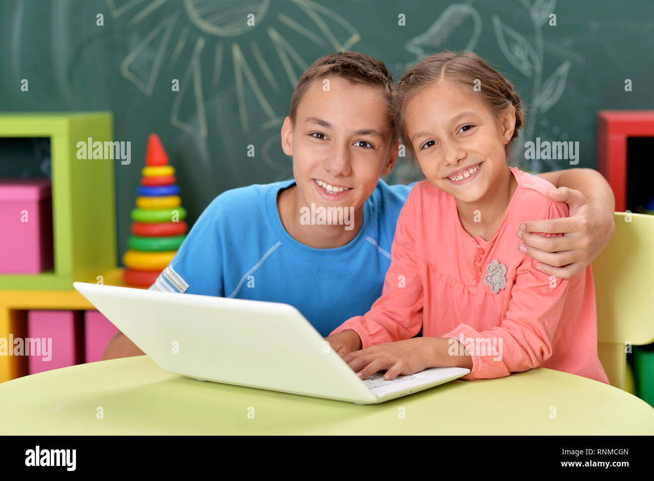 Portrait of brother and sister using laptop Stock Photo - Alamy
