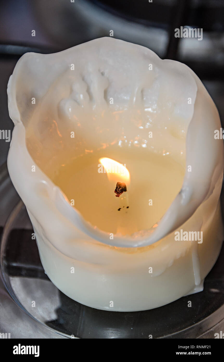 Burning white candle, melted wax, close up flame Stock Photo - Alamy