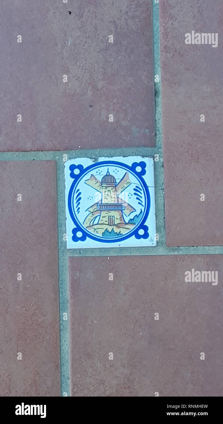 Floor tiles with little pictorial tiles interspersed between terracotta ...