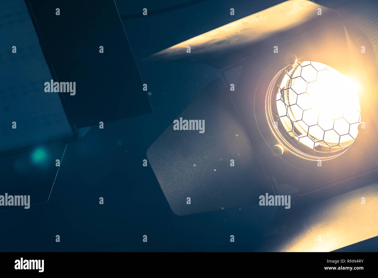 Professional orange studio spotlight hanging on the ceiling. Lighted ...