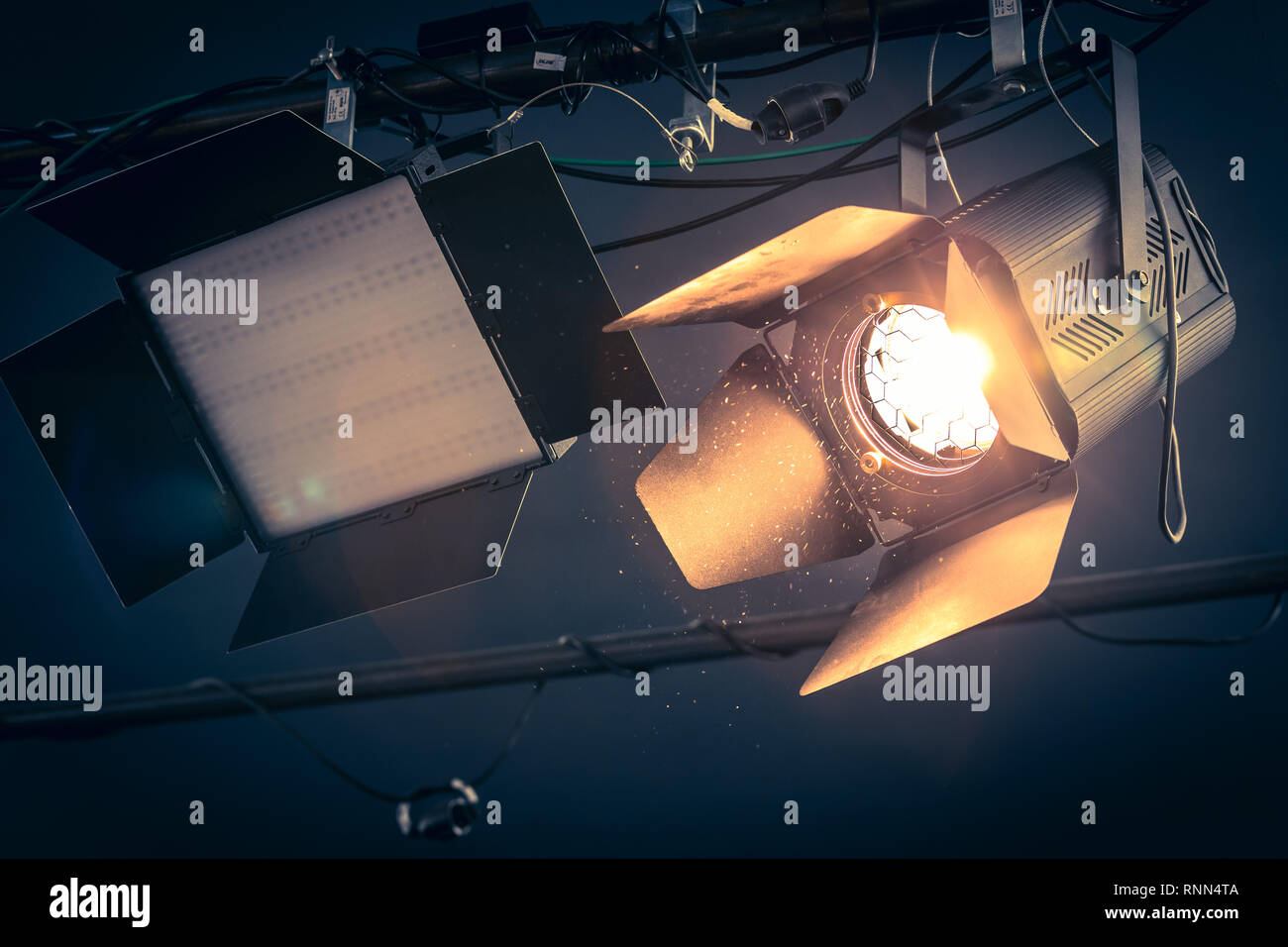 Professional orange studio spotlight hanging on the ceiling. Lighted ...