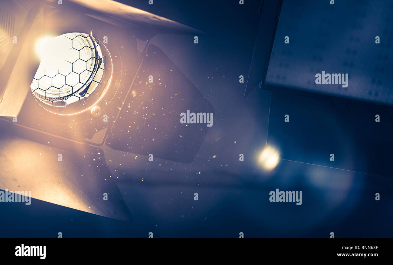 Professional orange studio spotlight hanging on the ceiling. Lighted ...