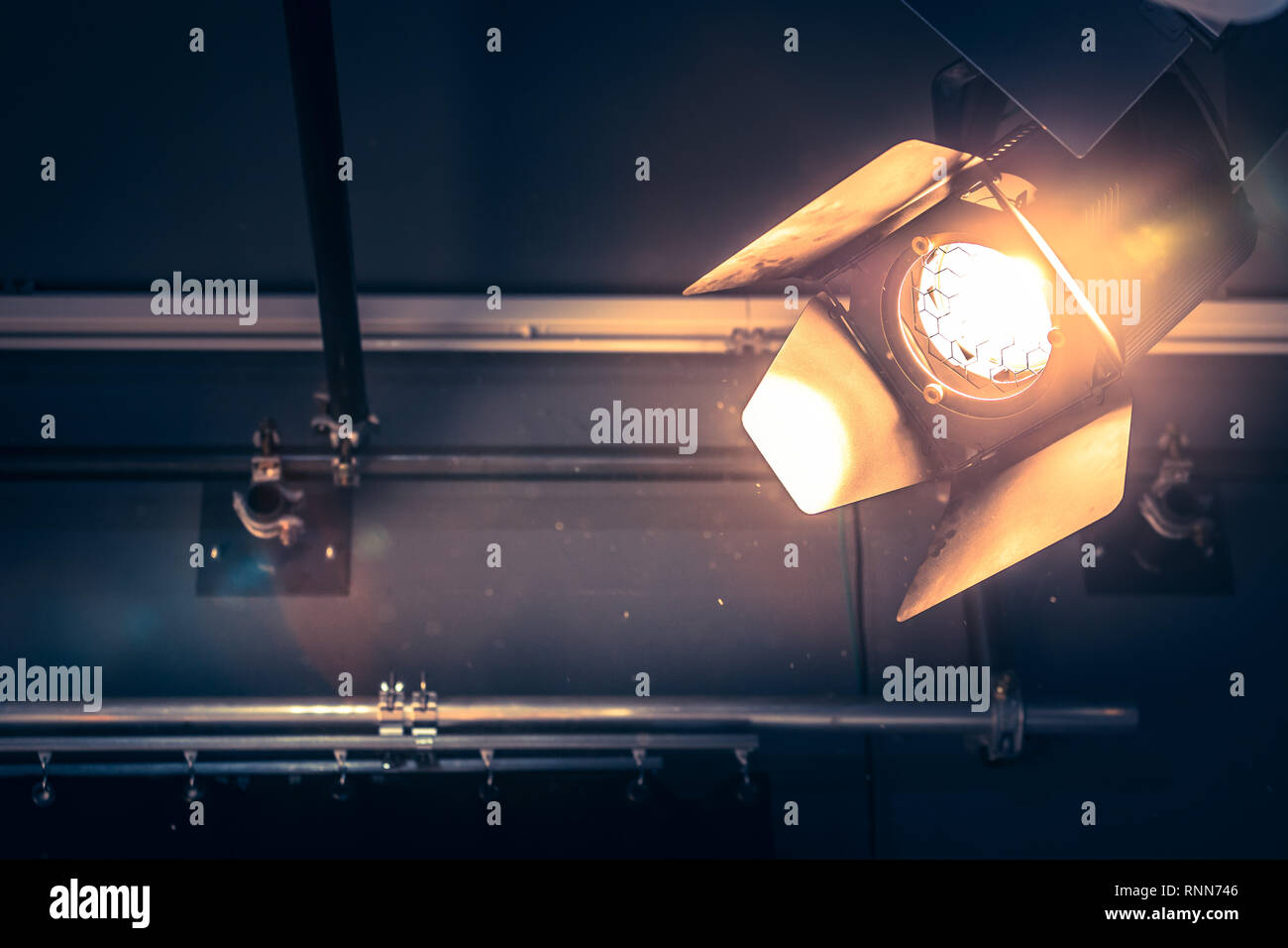 Professional orange studio spotlight hanging on the ceiling. Lighted ...