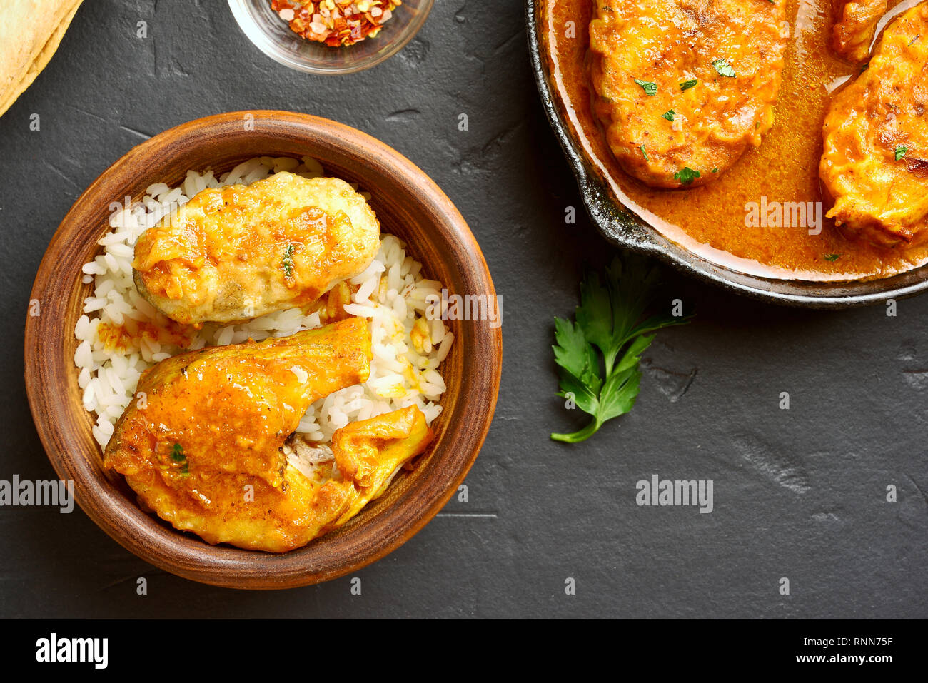 Fish curry with rice in wooden bowl on black stone background with copy ...