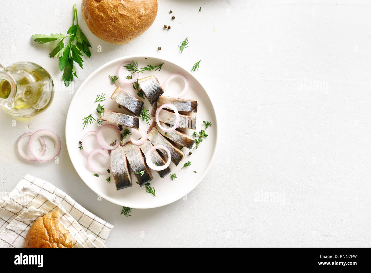 Tasty salted herring fillet with spice, herbs and onion on plate on ...