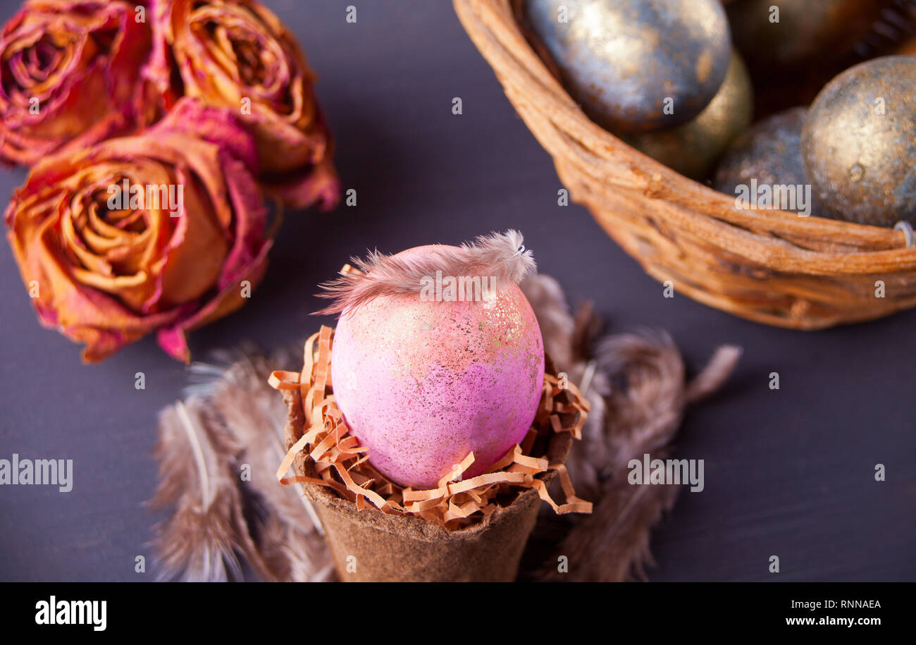 Easter pink color egg on the pot on the black wooden table Stock Photo ...