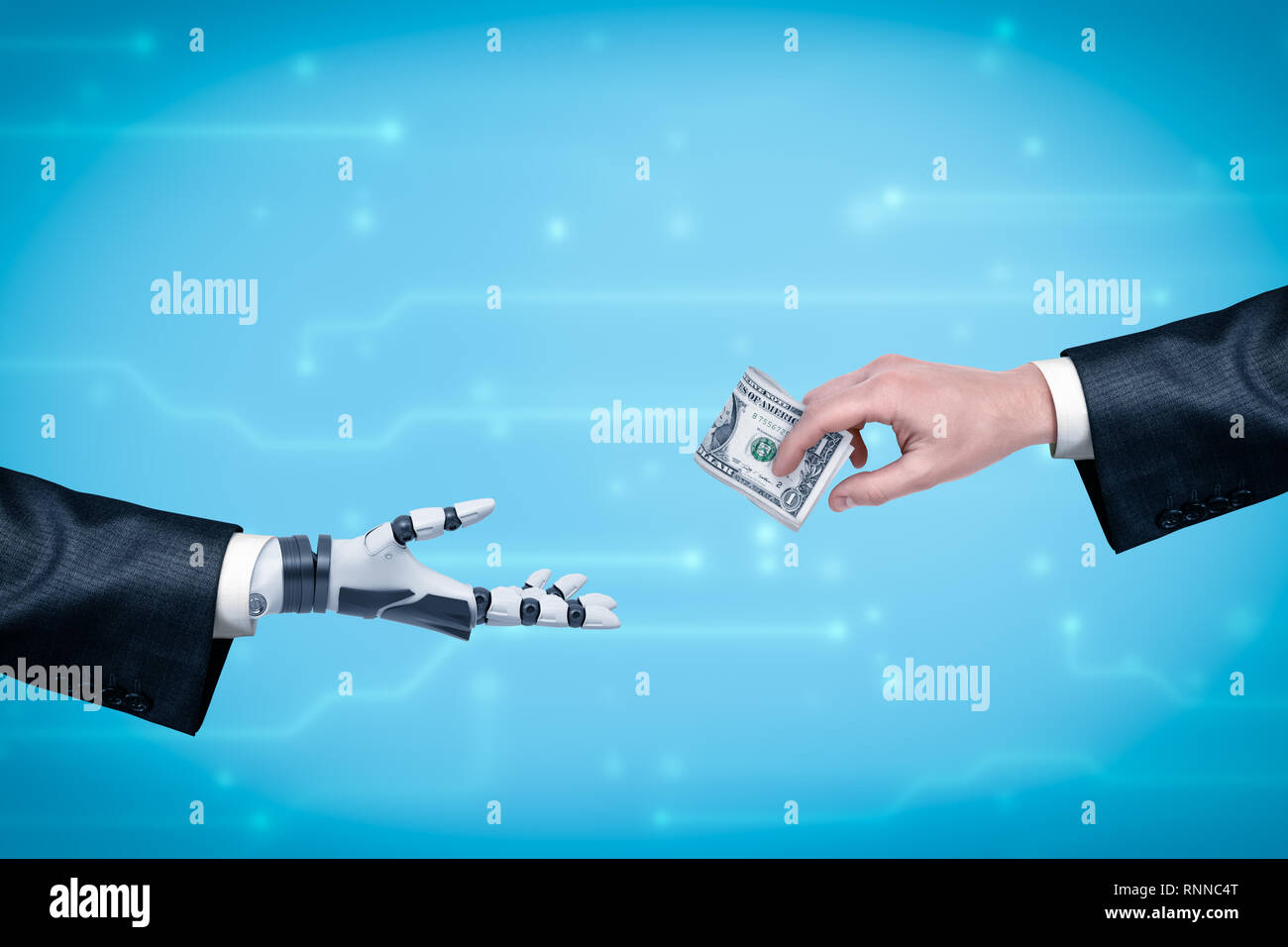 Side view of businessman's hand giving money to robot's hand on blue ...
