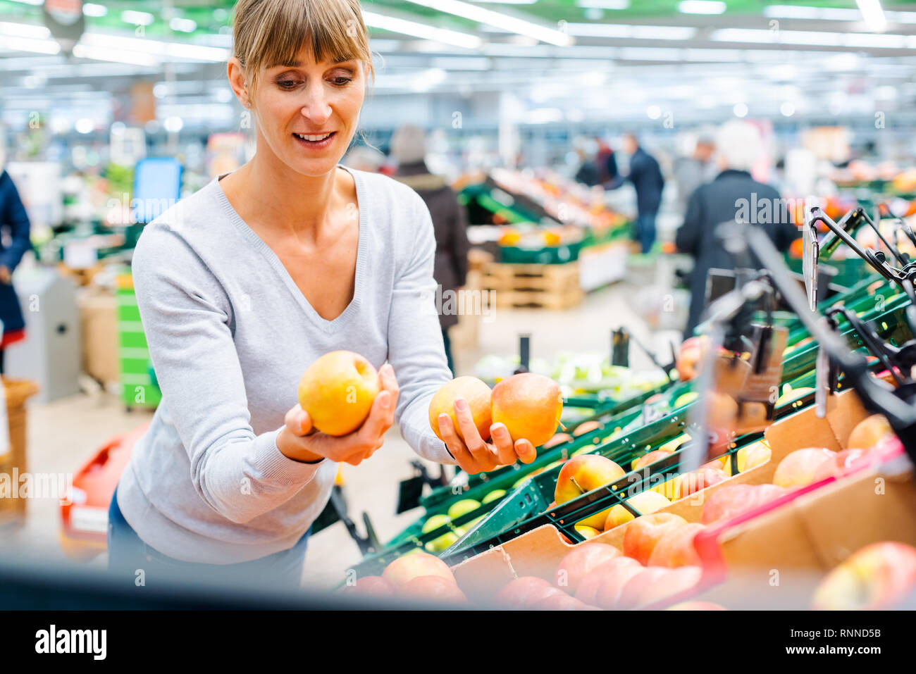 Woman testing the fresh fruit in a supermarket shelf Stock Photo - Alamy