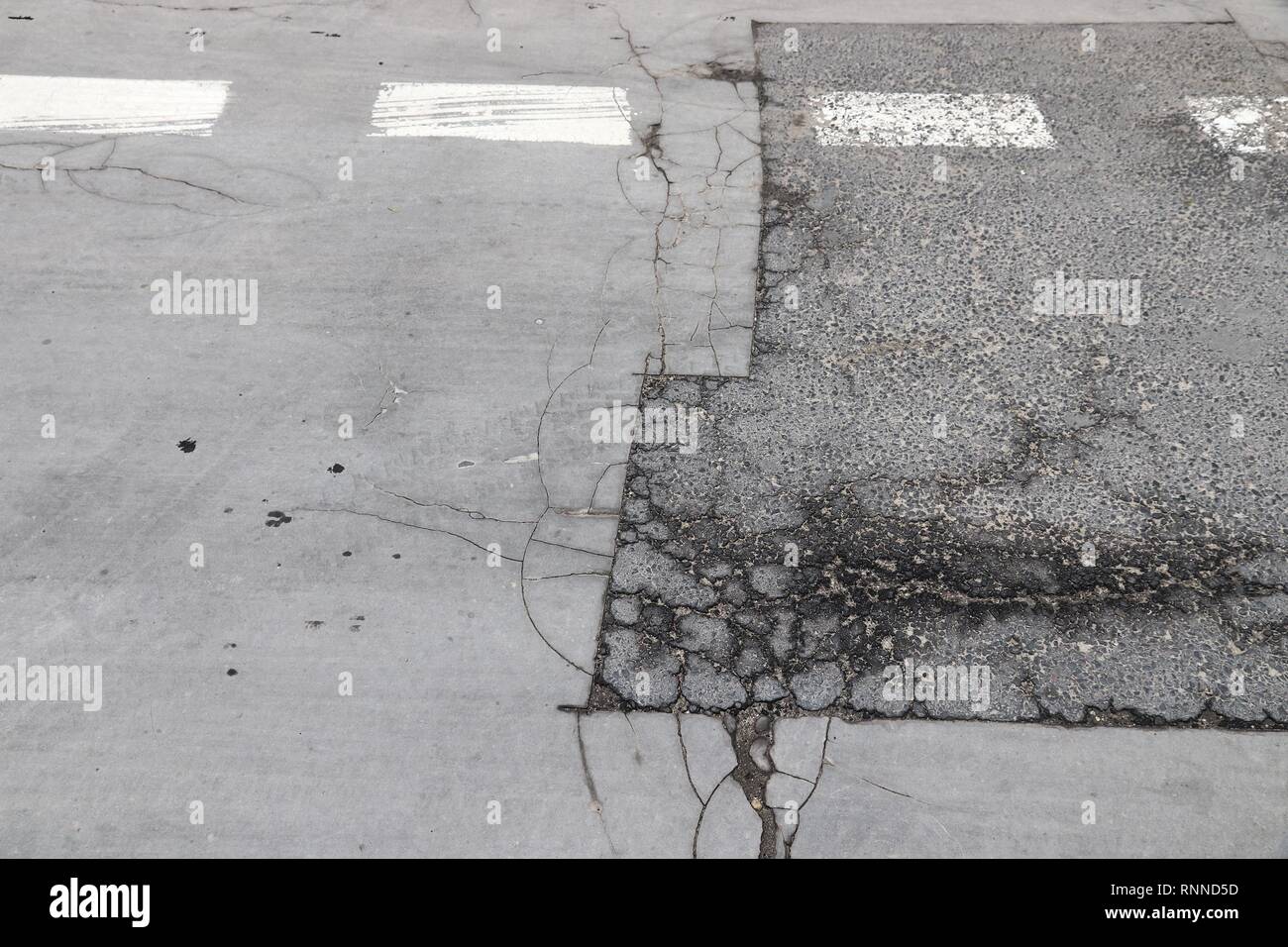 Damaged city street - cracks and patches on surface Stock Photo - Alamy