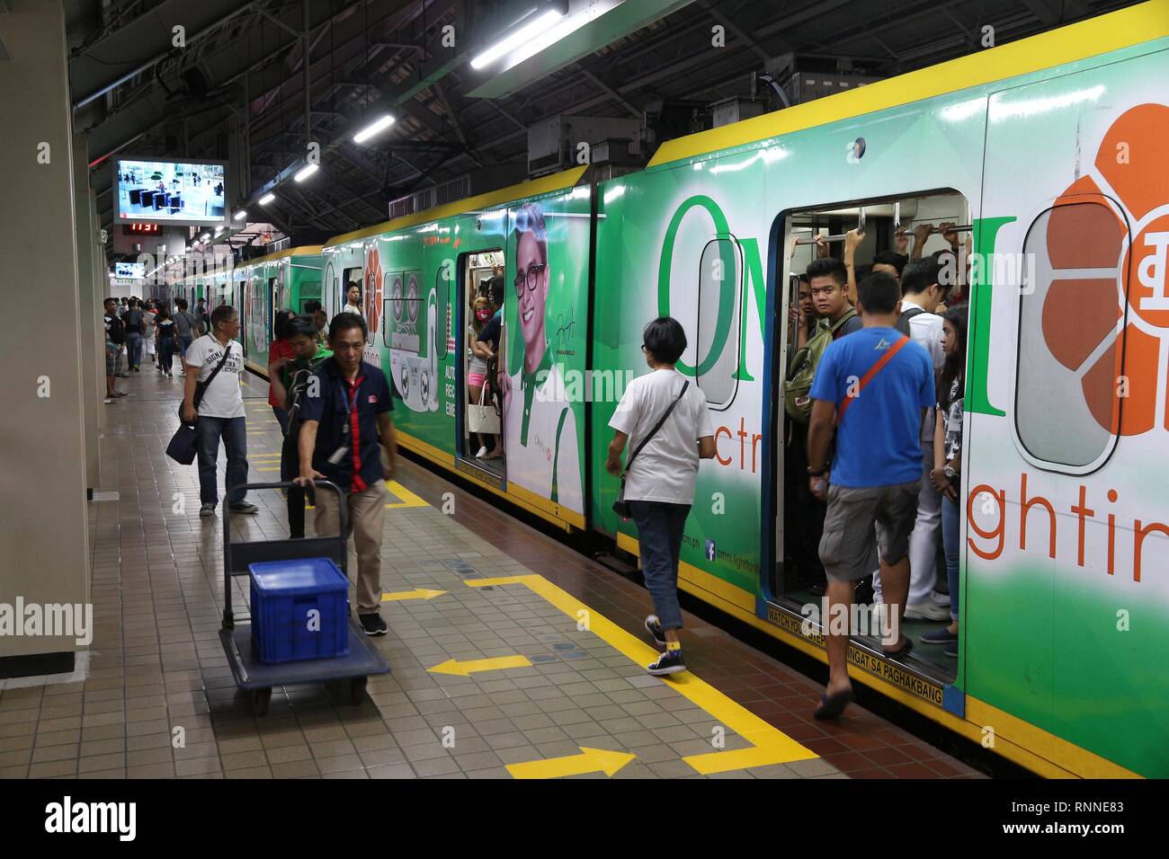 MANILA, PHILIPPINES - NOVEMBER 25, 2017: People board a Light Rail ...