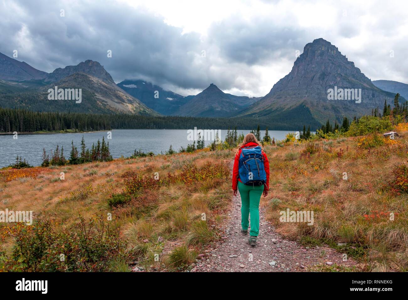 Woman walking on a hiking trail, Two Medicine Lake, Glacier National ...