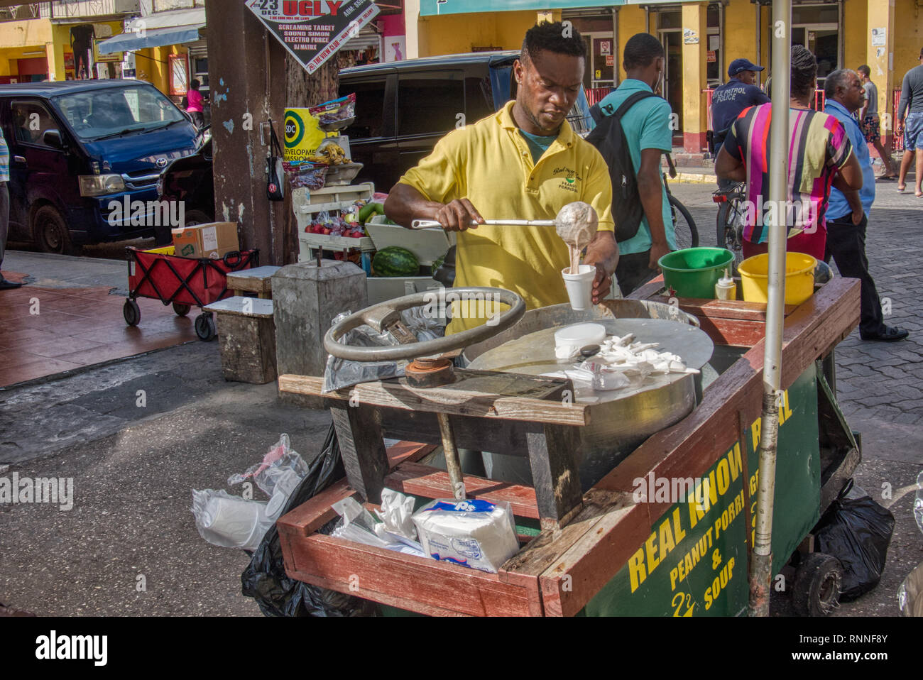 Peanut porridge vendor sells his soup from a cart on the street corner ...