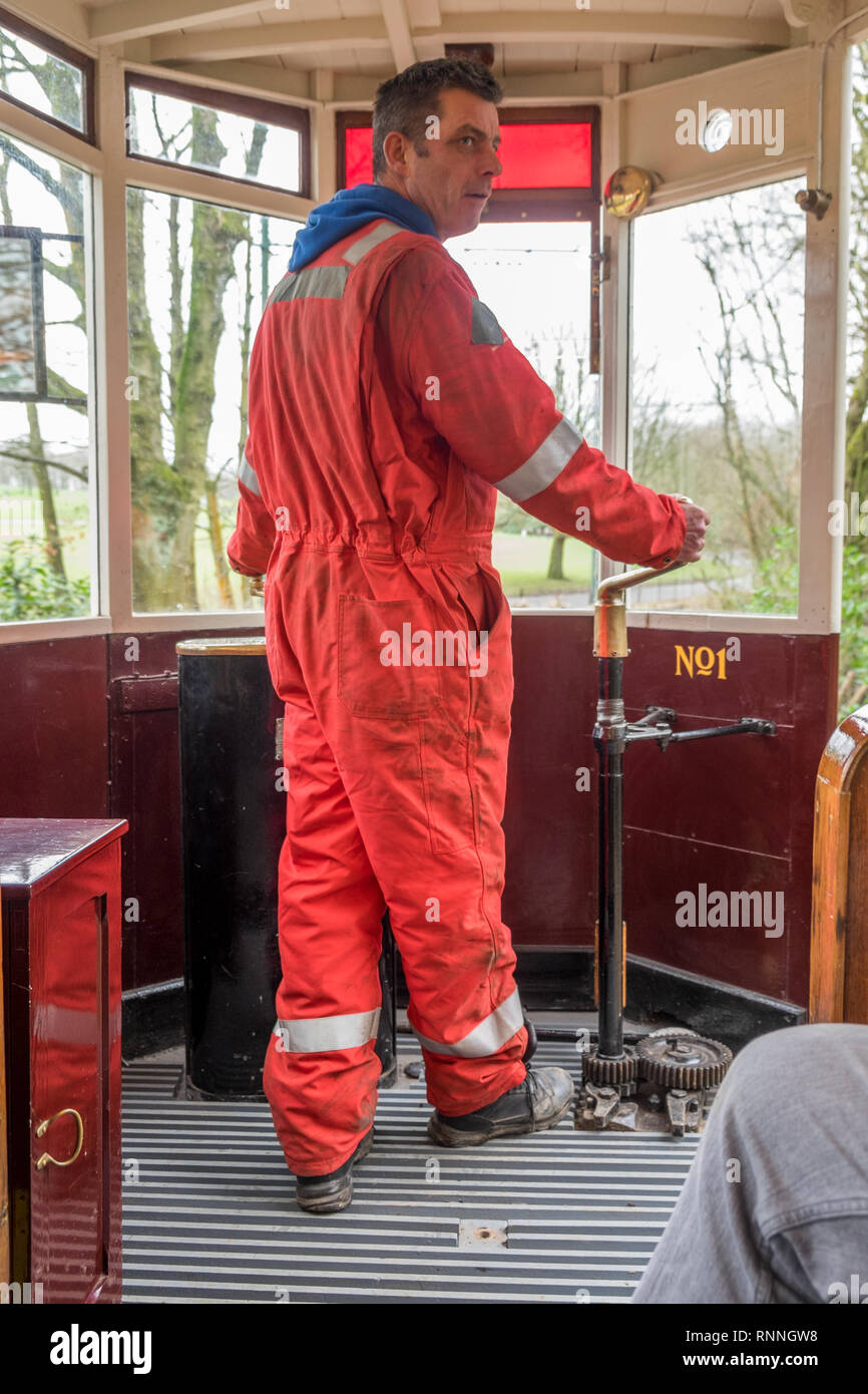 Engineer driving the heritage tram using the brake lever to control the ...
