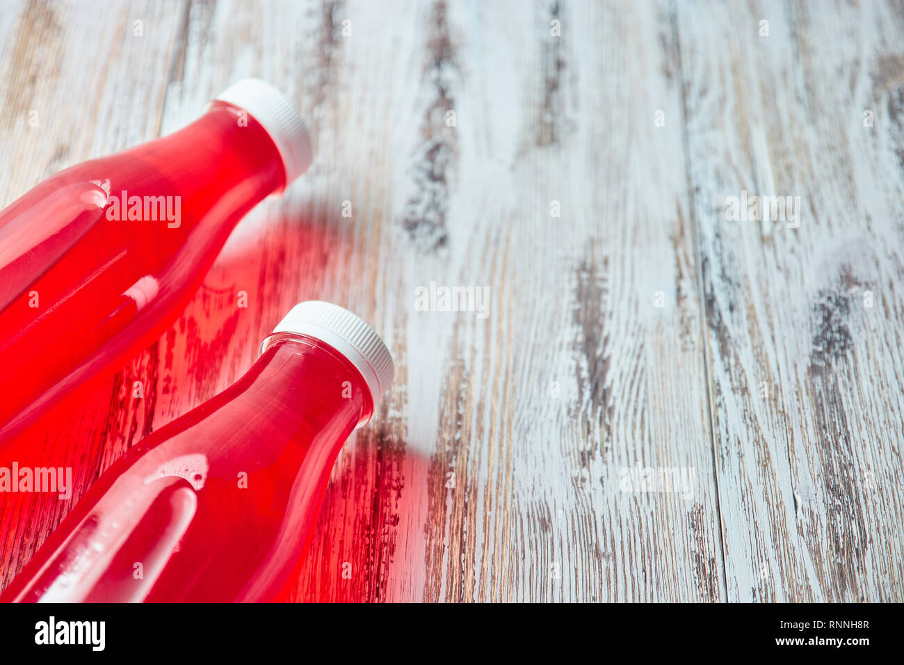 Plastic soda bottle berry juice drink on wooden background. a couple of ...
