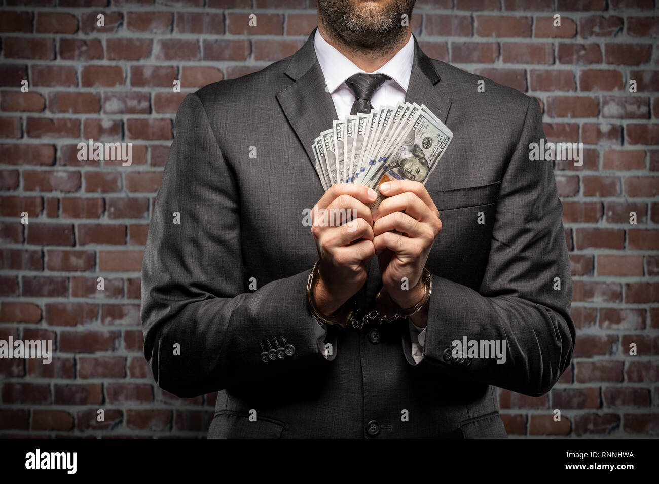 Brazilian man holding bills of money with a handcuff in a jail. concept ...