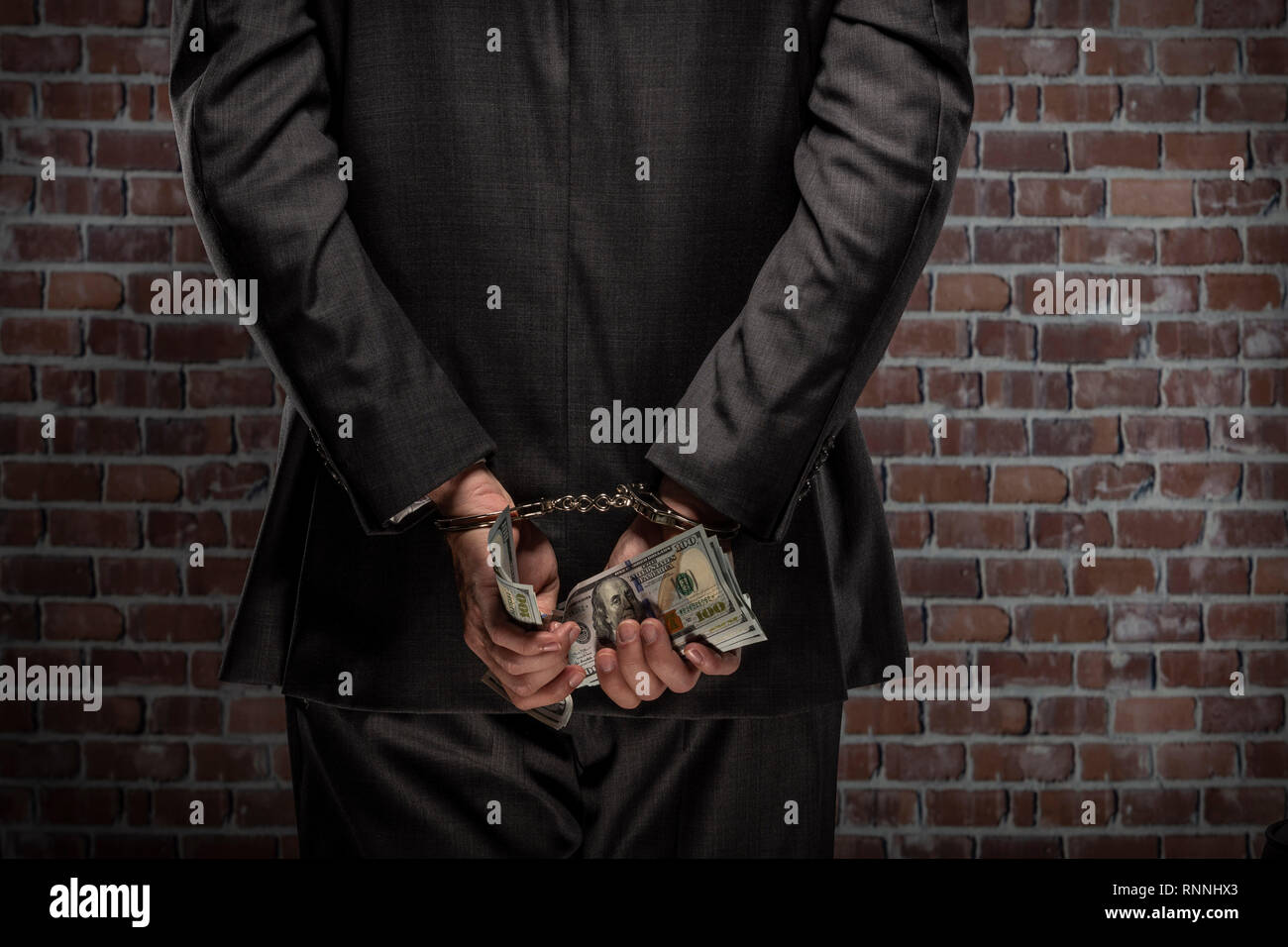 Brazilian man holding bills of money with a handcuff in a jail. concept ...