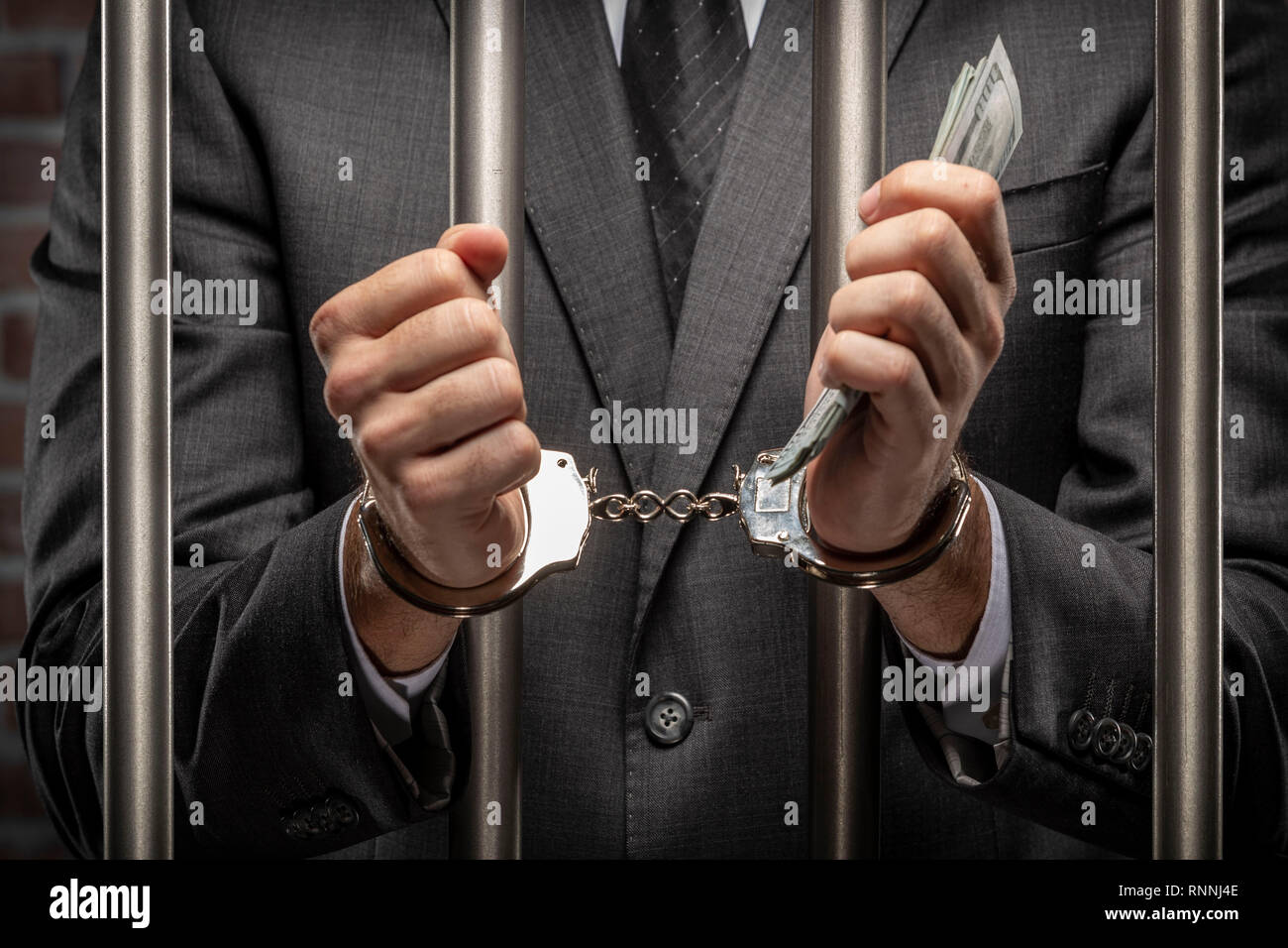 Brazilian man holding bills of money with a handcuff in a jail. concept ...
