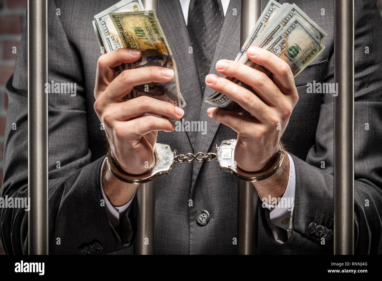 Brazilian man holding bills of money with a handcuff in a jail. concept ...