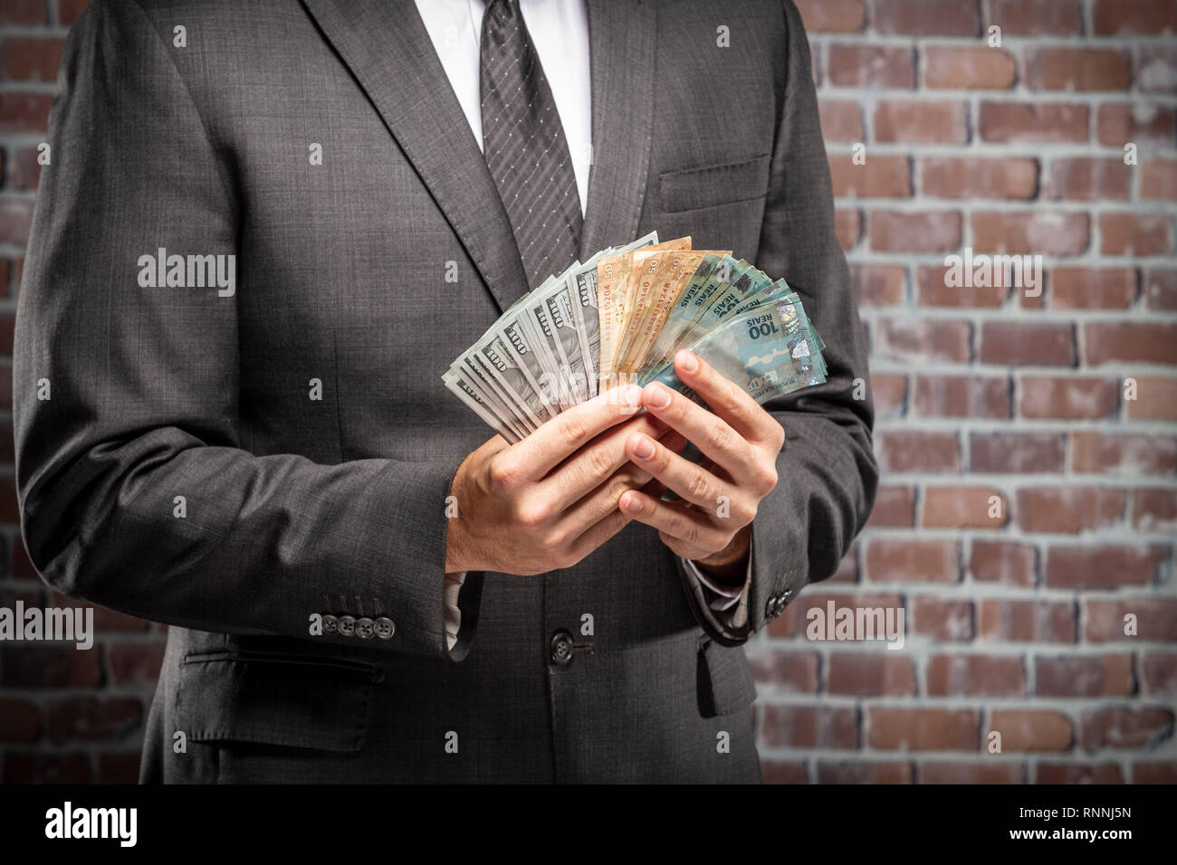 Brazilian man holding bills of money with a handcuff in a jail. concept ...