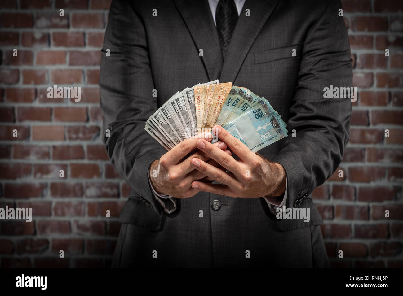 Brazilian man holding bills of money with a handcuff in a jail. concept ...